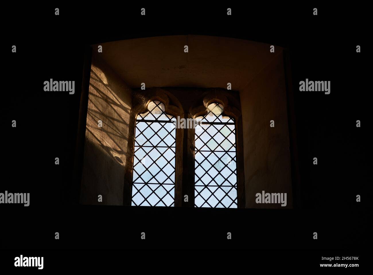 Interior of church with light falling through glass lead window Stock ...