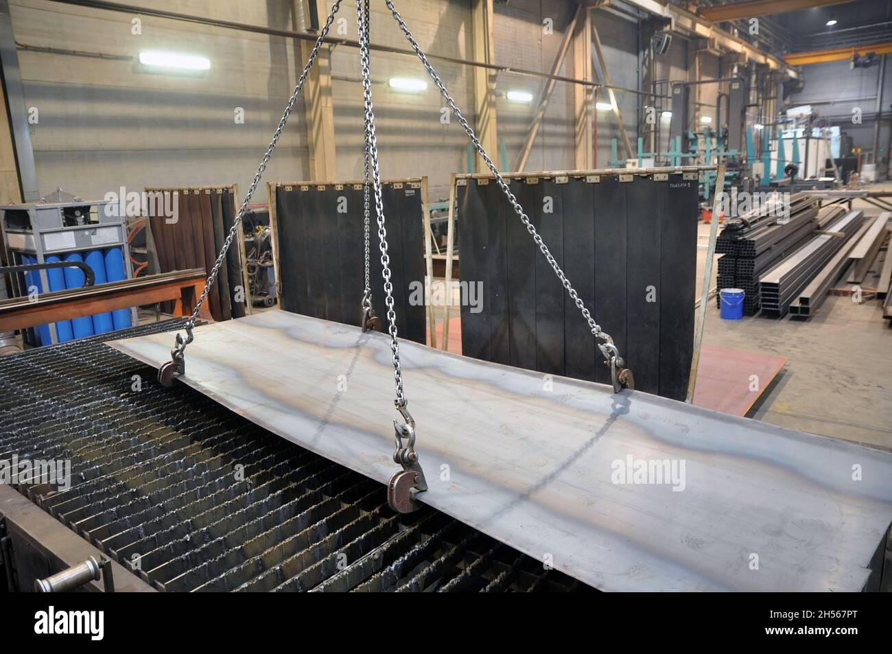 Lifting chains and hooks for loading sheet metal. Placing metal on a ...