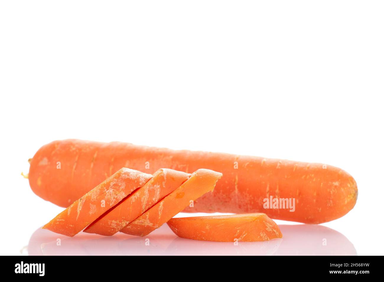 One fresh organic, unpeeled carrot cut into slices, close-up, isolated ...