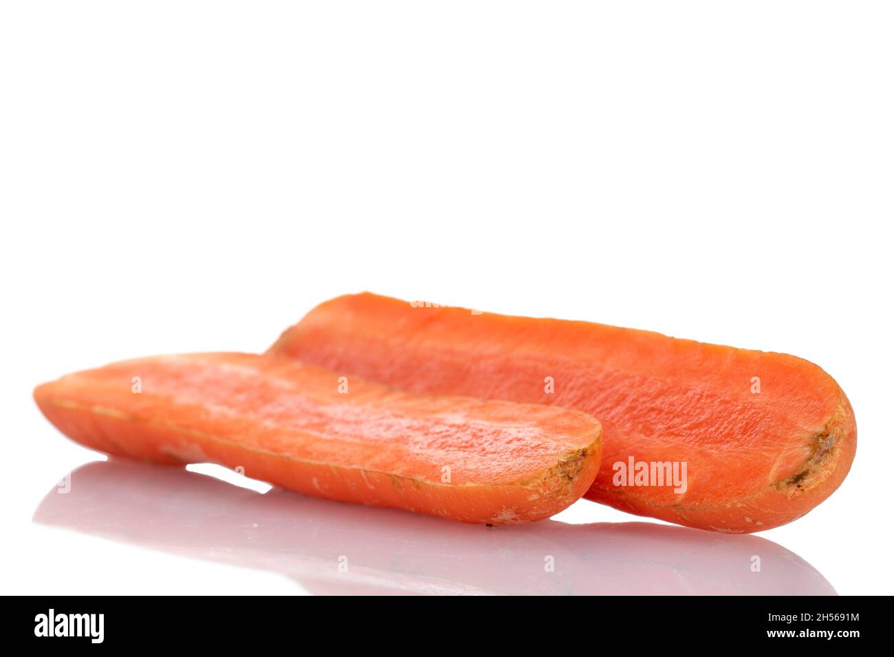 One ripe red unpeeled carrot, cut in half, close-up, isolated on white ...