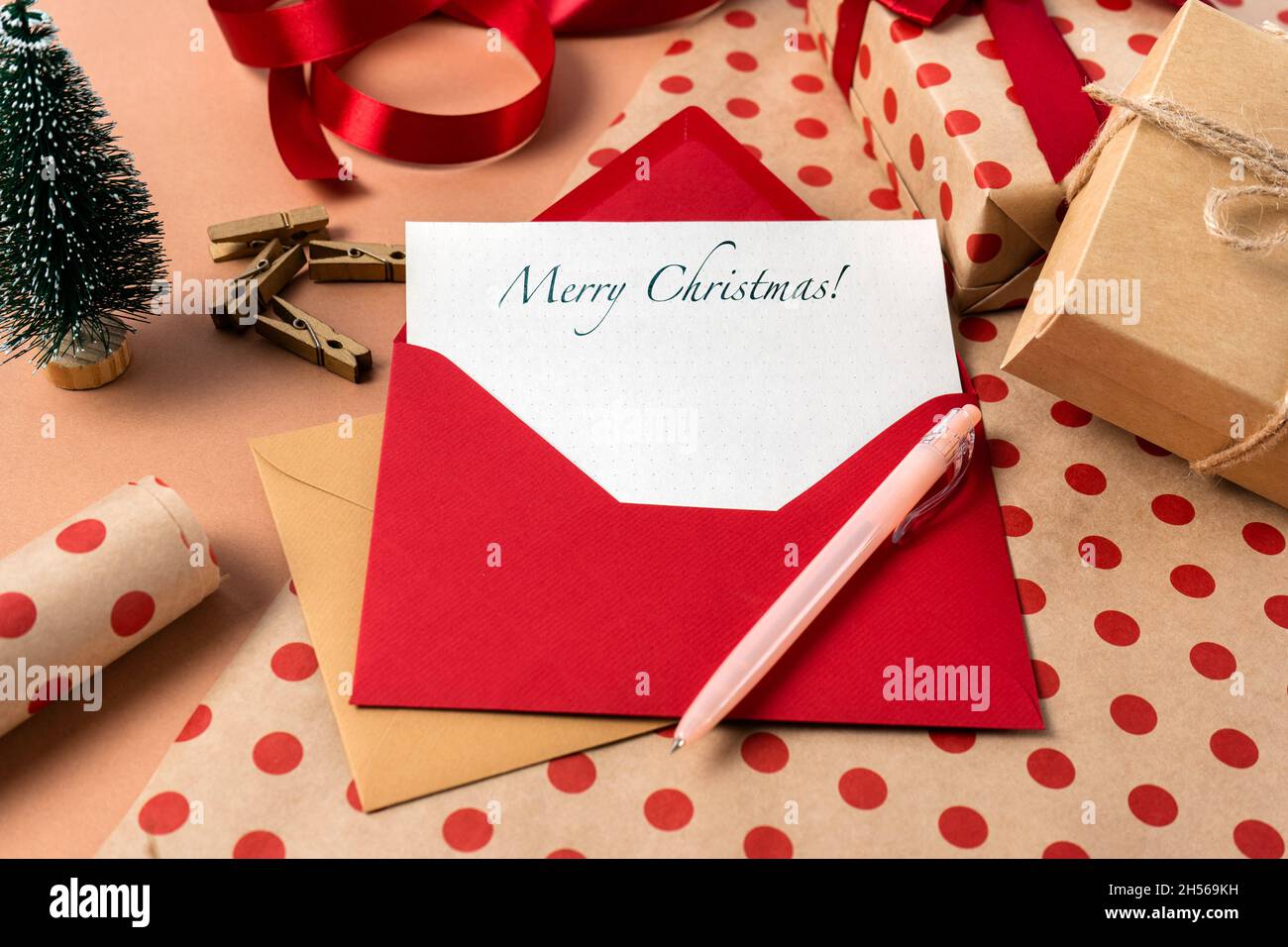 Christmas card with wishes in a red envelope on the background of gift ...