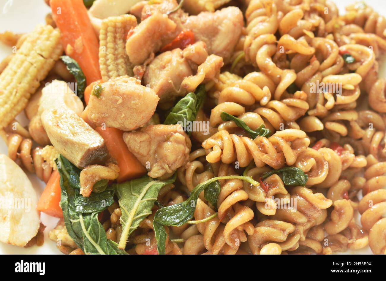 spicy stir fried fusilli pasta with chicken and vegetable in chili Thai ...