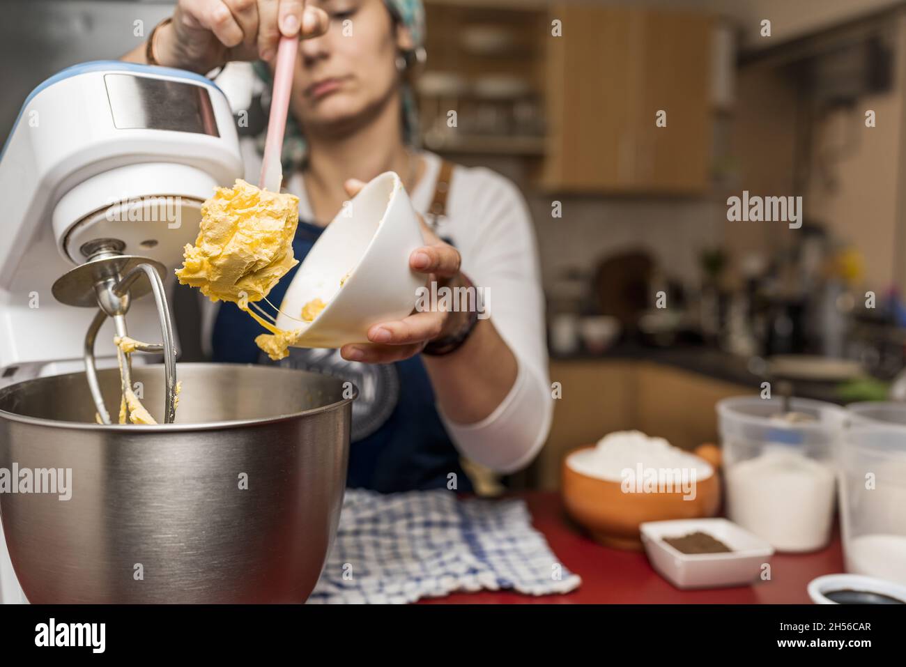 A female cook putting butter into the bowl of an electric mixer Stock ...
