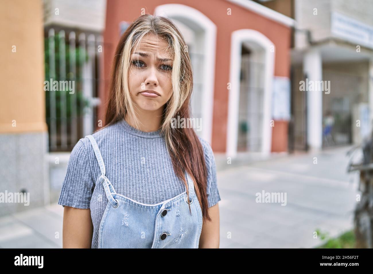 Young caucasian woman outdoors depressed and worry for distress, crying ...
