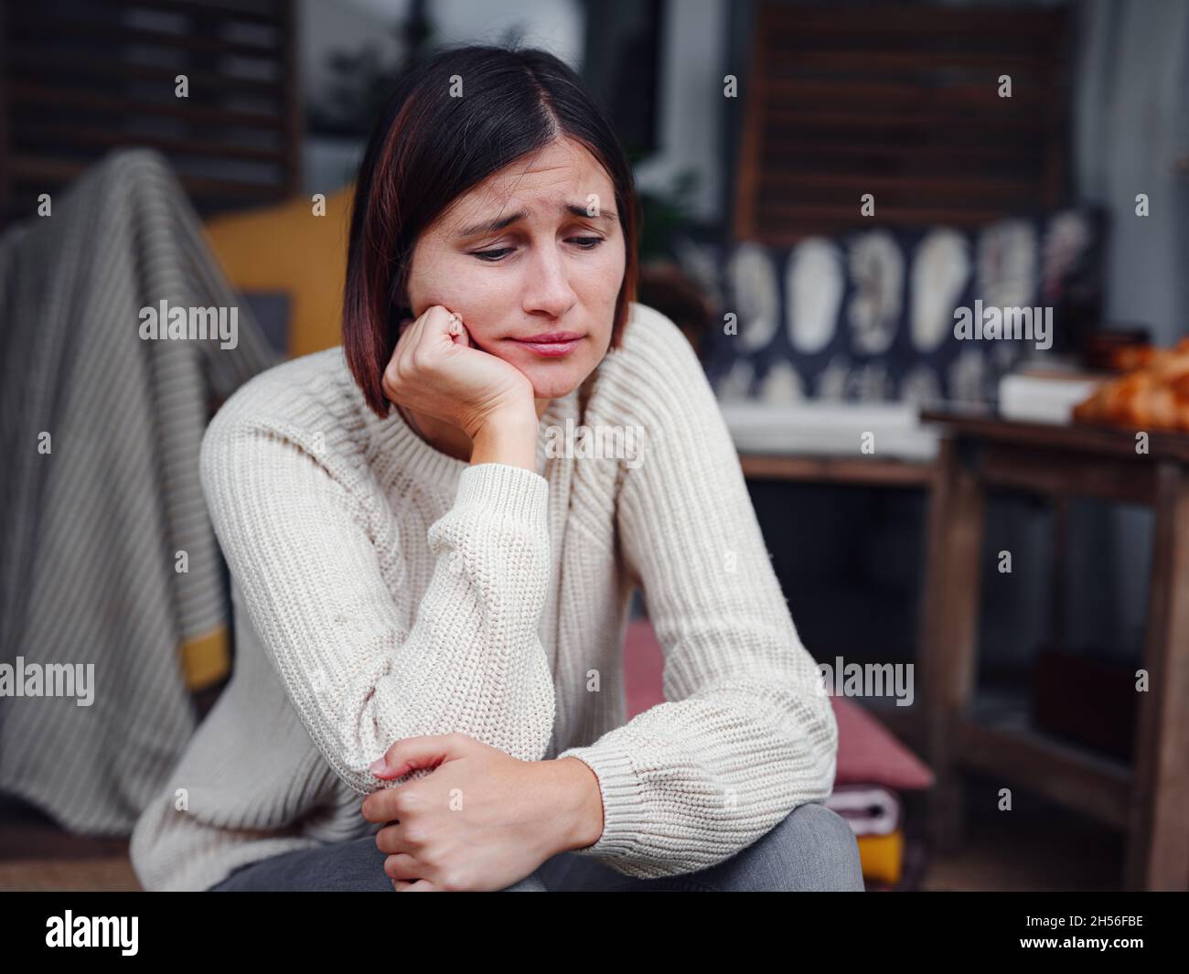Young depressed asian woman sitting on porch of backyard. She feeling ...
