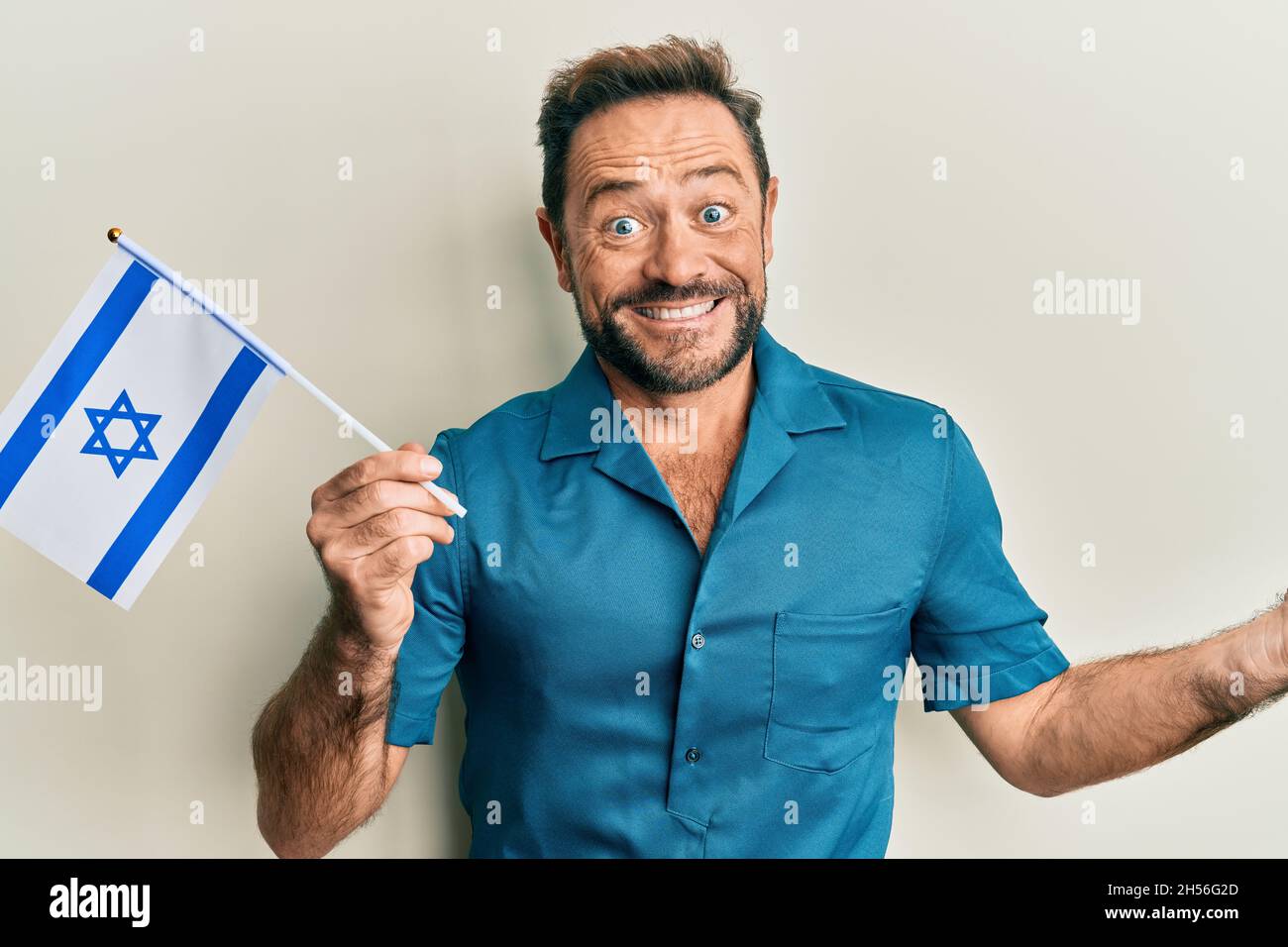 Middle age man holding israel flag celebrating achievement with happy ...