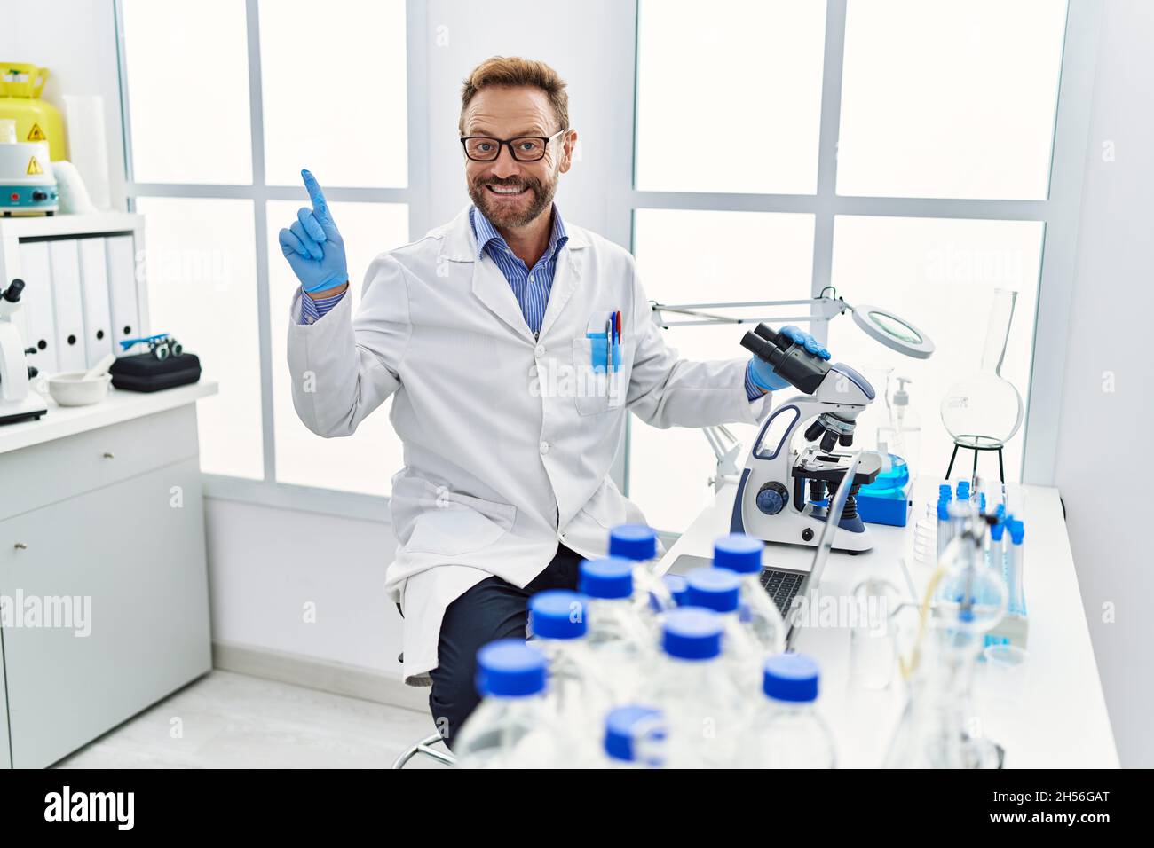 Middle age man working at scientist laboratory smiling happy pointing ...