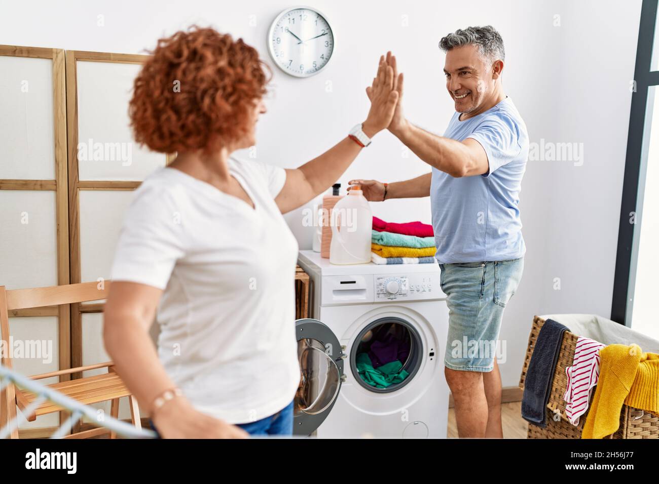 Middle age man and woman couple high five raised up hands hanging ...