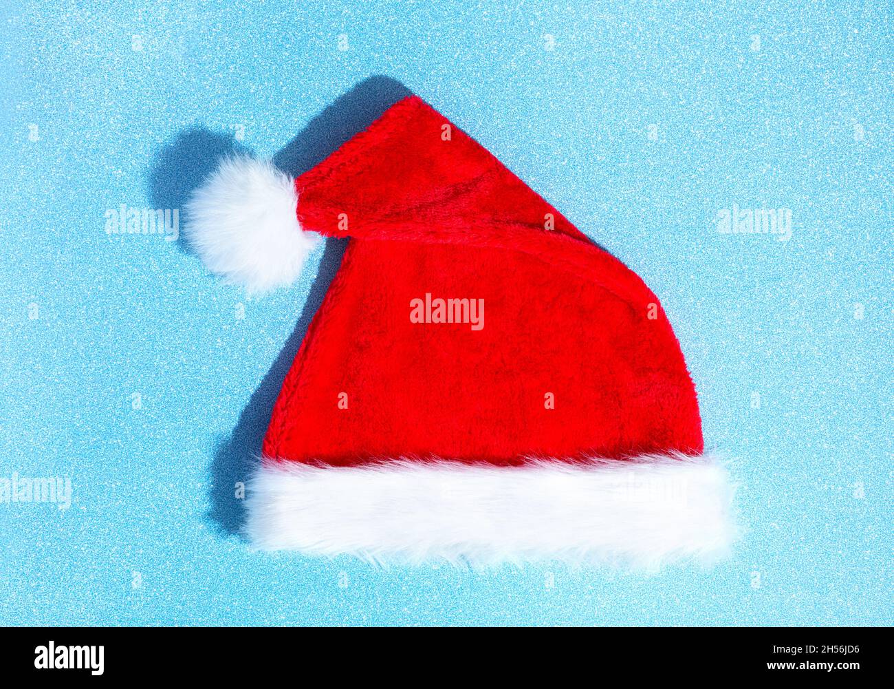 Christmas red Santa Claus hat on shiny blue background Stock Photo - Alamy