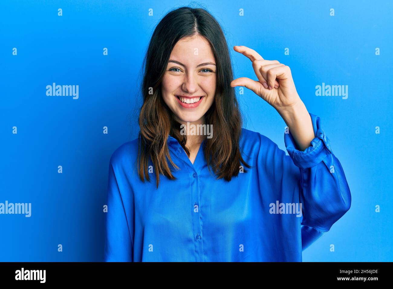 Young brunette woman wearing casual blue shirt smiling and confident ...