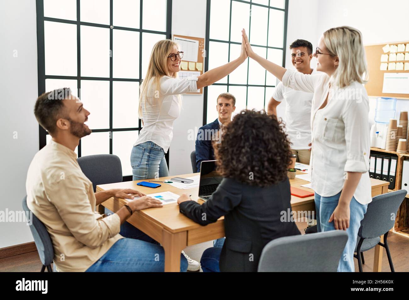 Two workers smiling happy high five during meeting at the office Stock ...