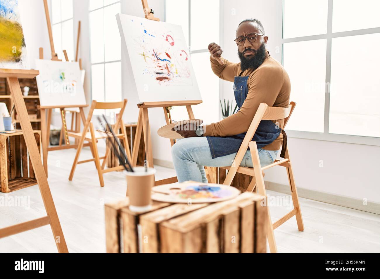 African american artist man painting on canvas at art studio with angry ...