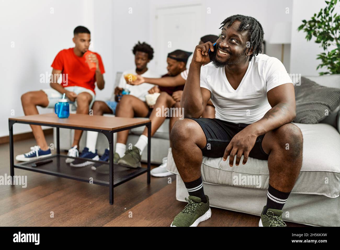 Group of african american people sitting on the sofa at home. Man ...