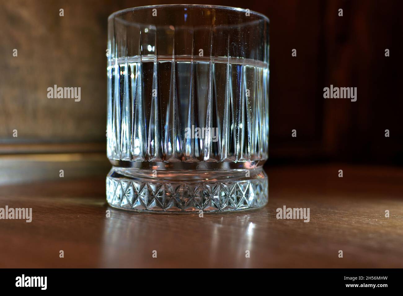 Sharp edges of a glass close up on table in dark lighting Stock Photo ...
