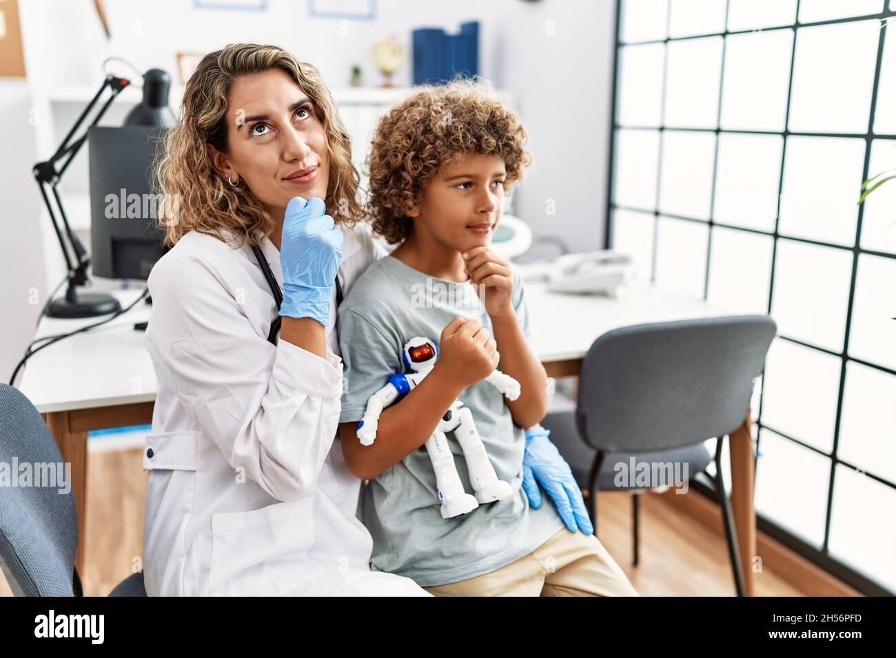 Young kid at pediatrician clinic holding teddy bear serious face ...