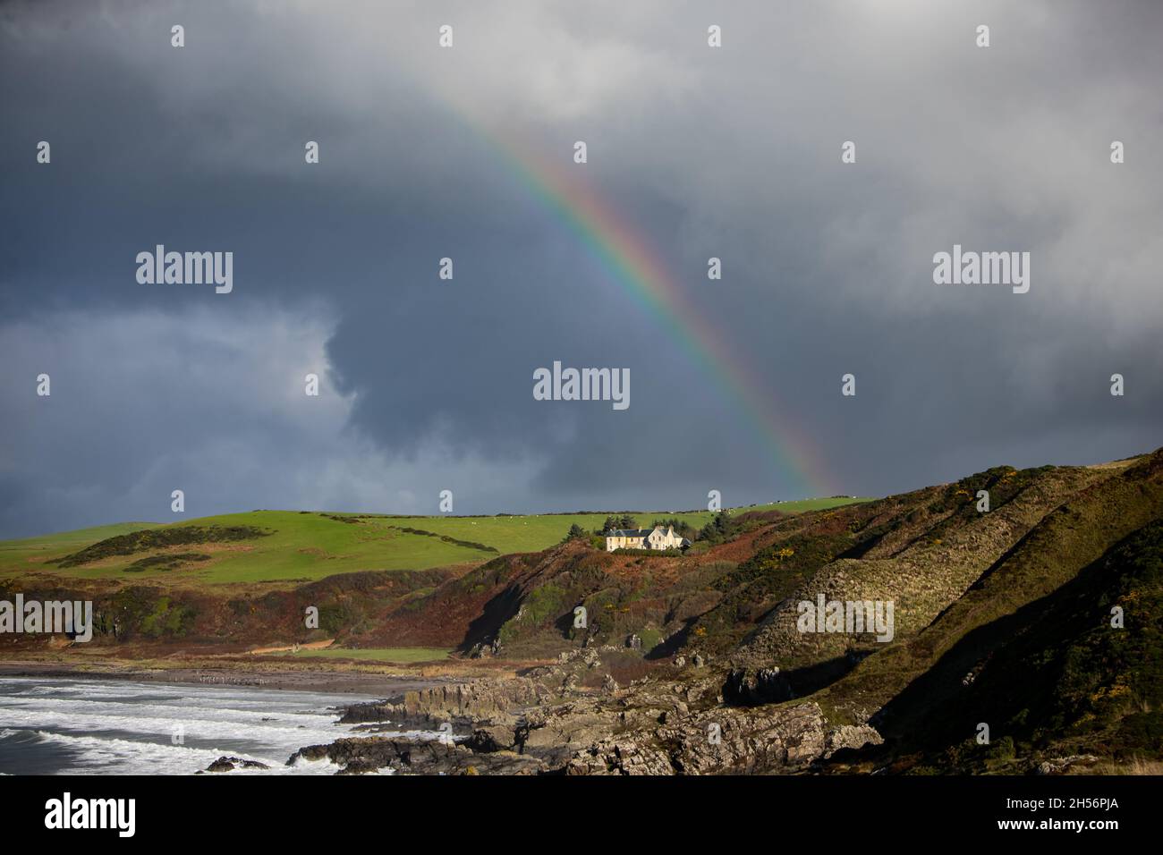 A rainbow emerges after a storm on the Dumfries & Galloway coast Stock ...