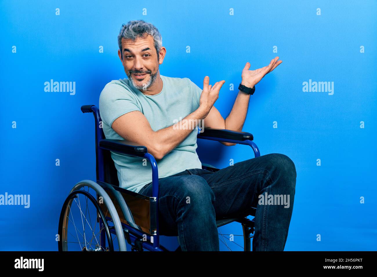 Handsome middle age man with grey hair sitting on wheelchair inviting ...