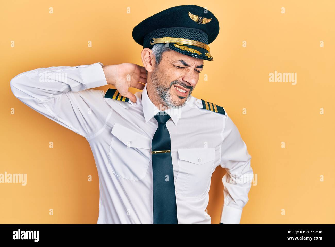 Handsome middle age man with grey hair wearing airplane pilot uniform ...