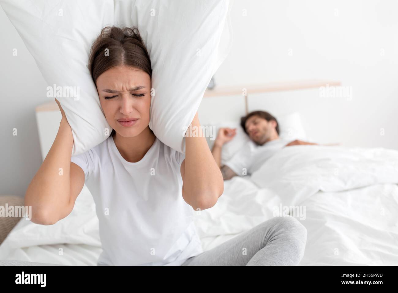 Unhappy Offended Angry Young Caucasian Female Sitting On Bed Covering