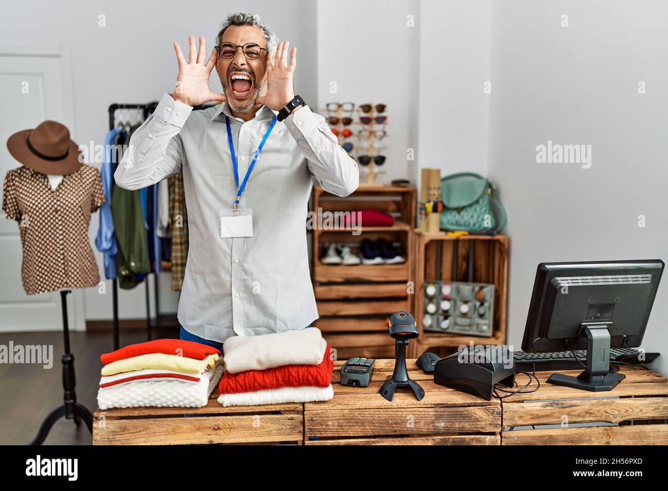 Middle age hispanic man working as manager at retail boutique smiling ...