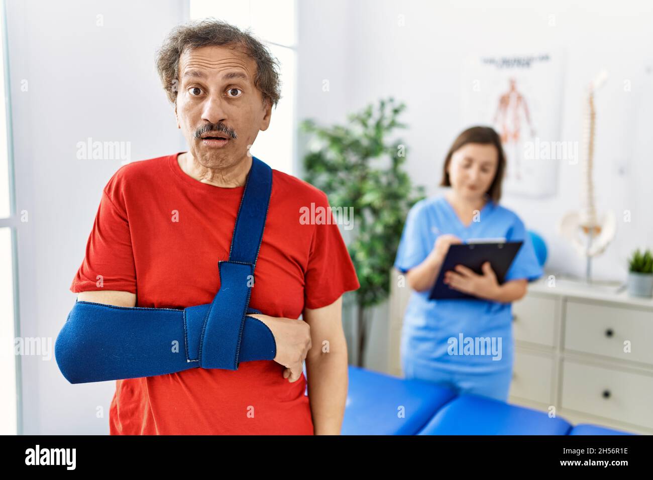 Southeast asian man wearing wearing arm on sling at rehabilitation ...