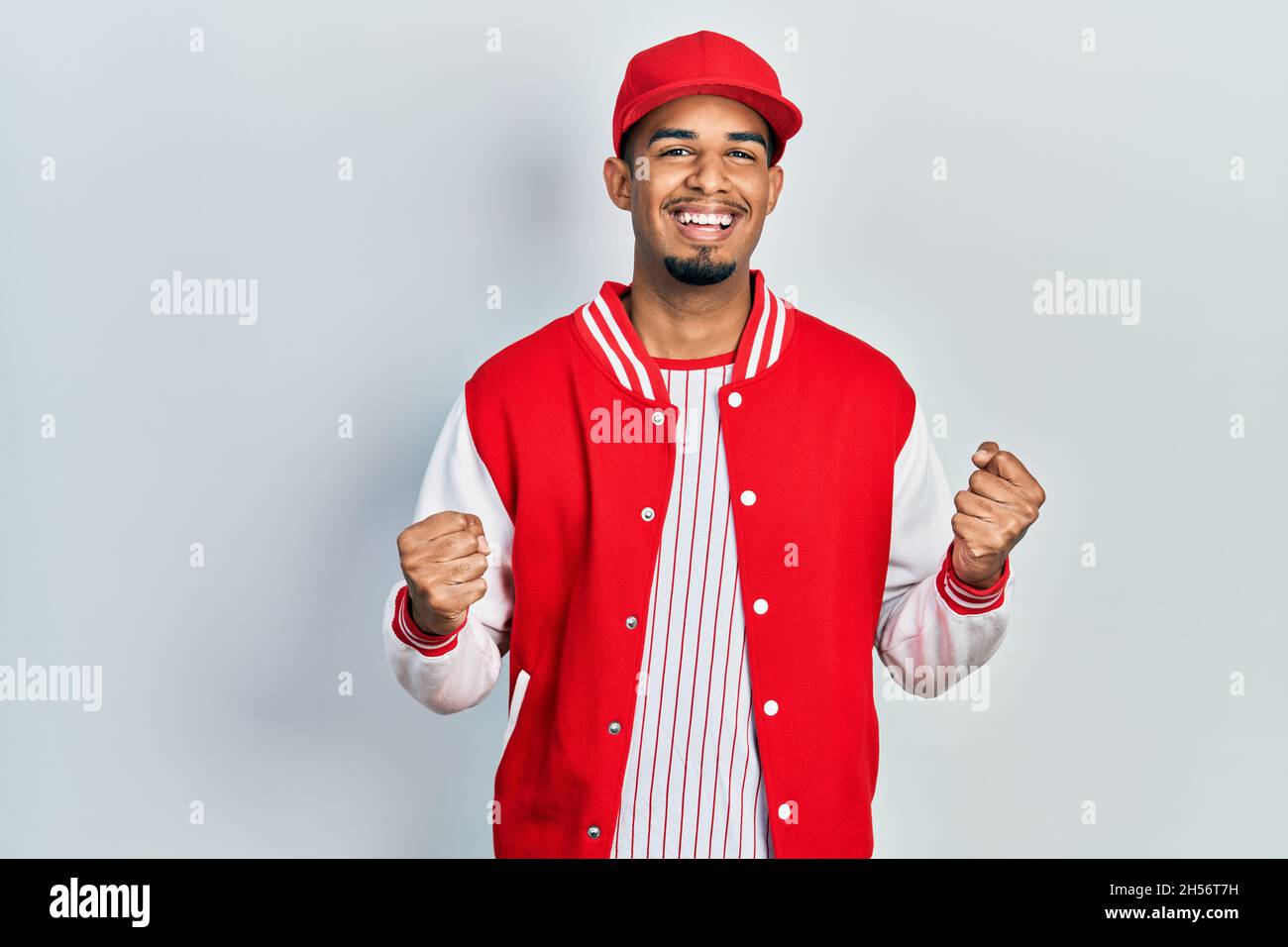 Young african american man wearing baseball uniform celebrating ...
