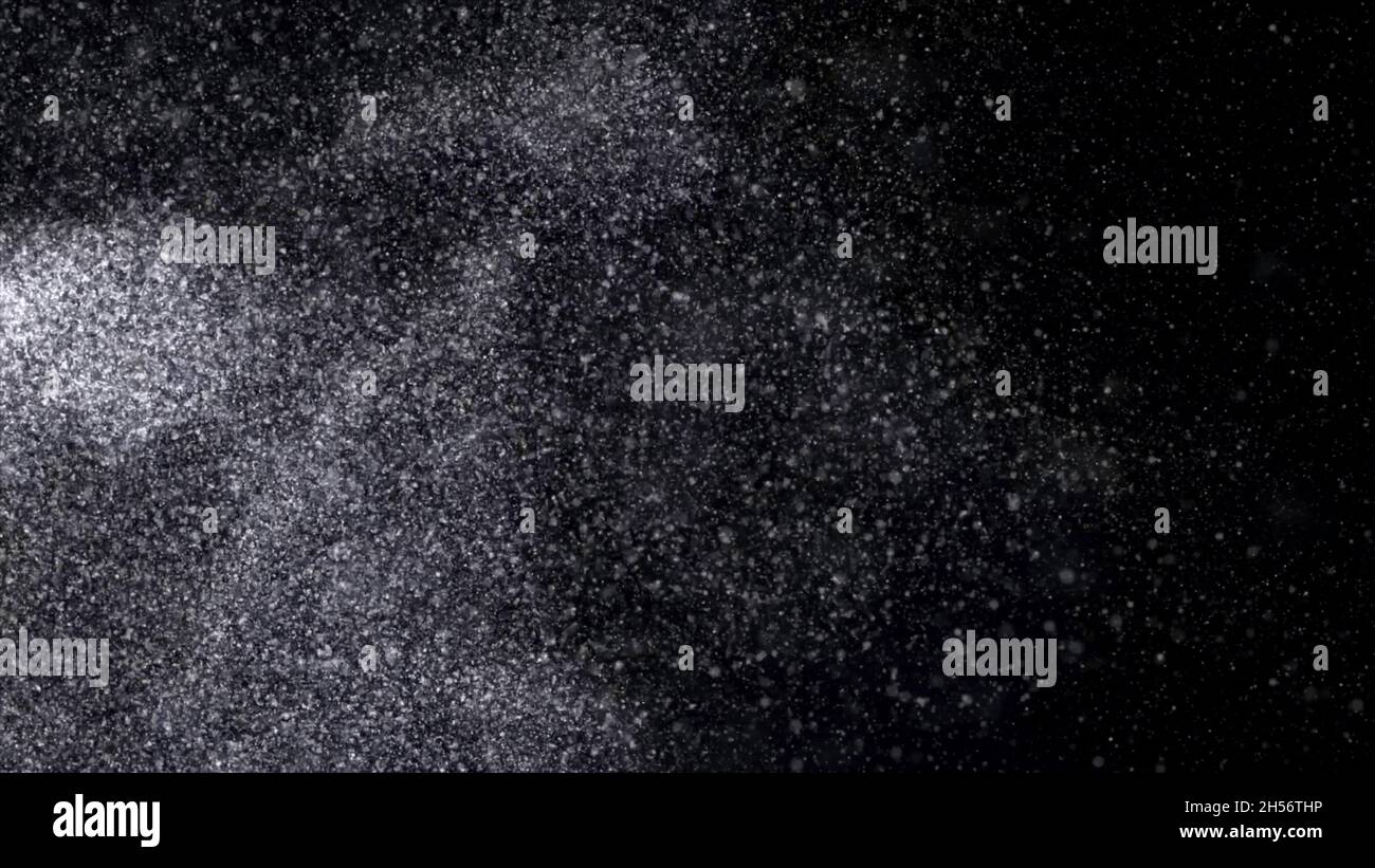 Abstract animation of small white particles exploding isolated on black ...