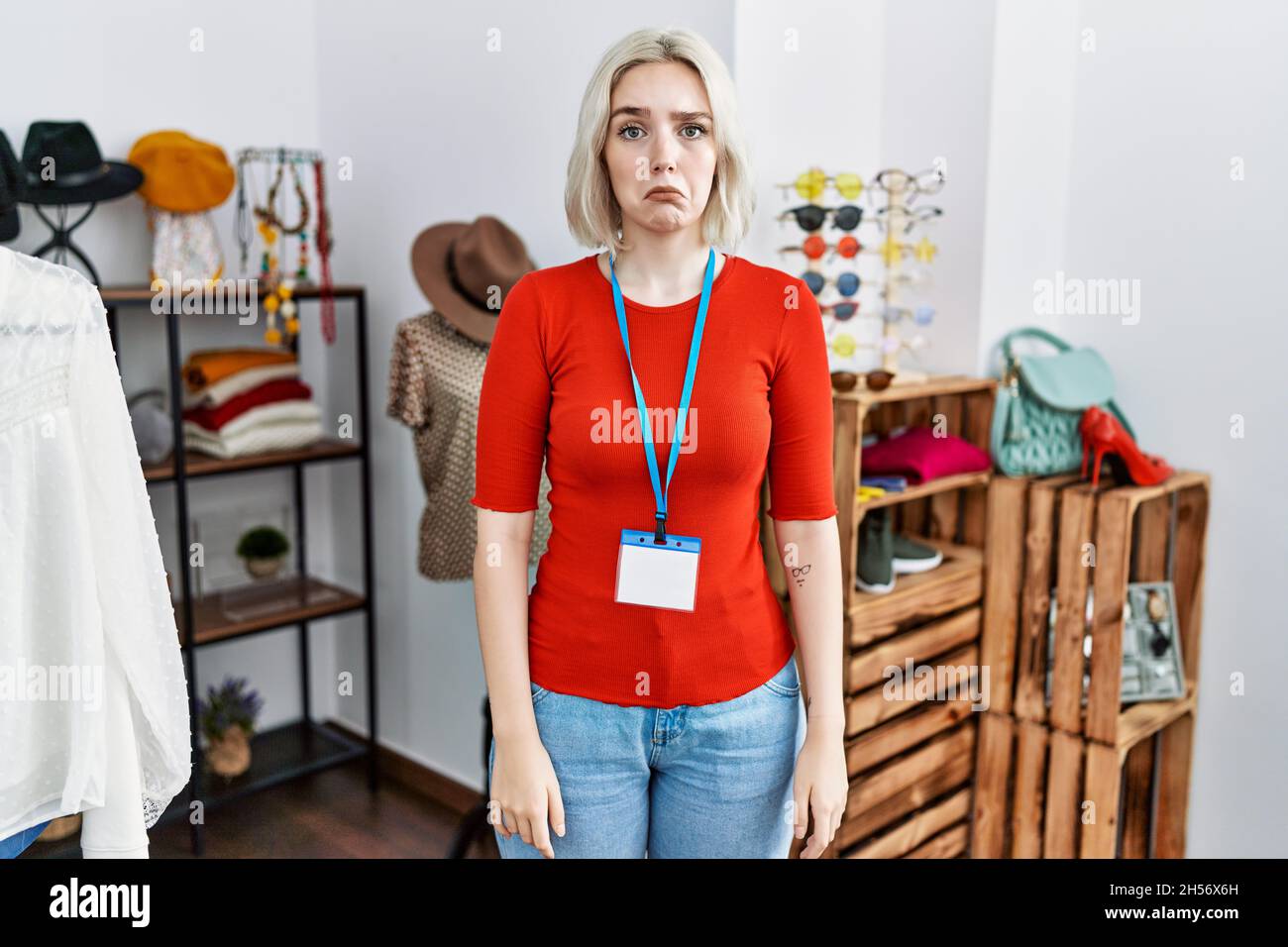 Young caucasian woman working as manager at retail boutique depressed ...