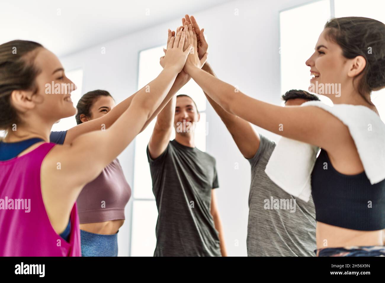 Group of young sporty people smiling happy high five with hands raised ...