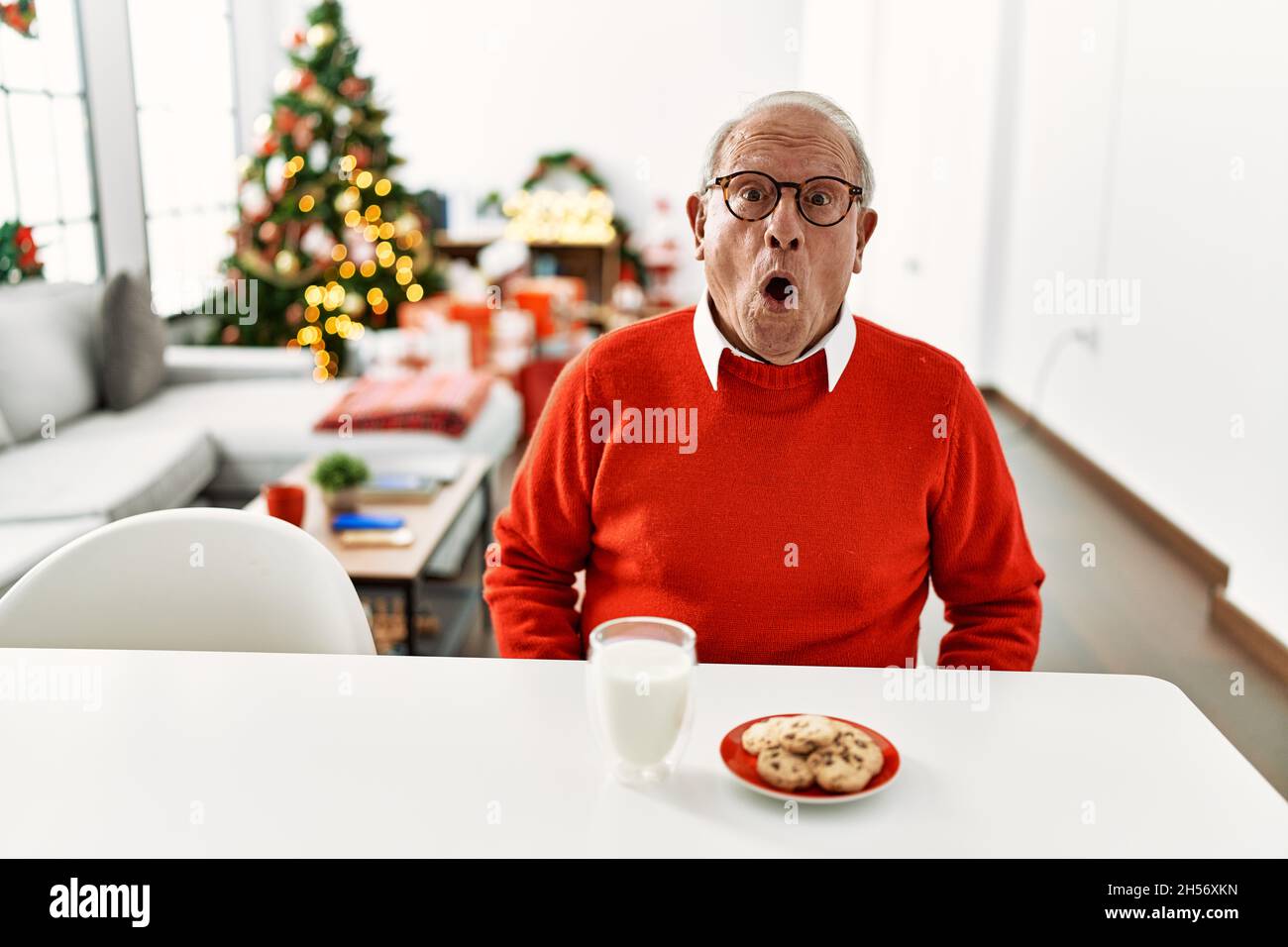 Senior man with grey hair sitting on the table with cookies by ...