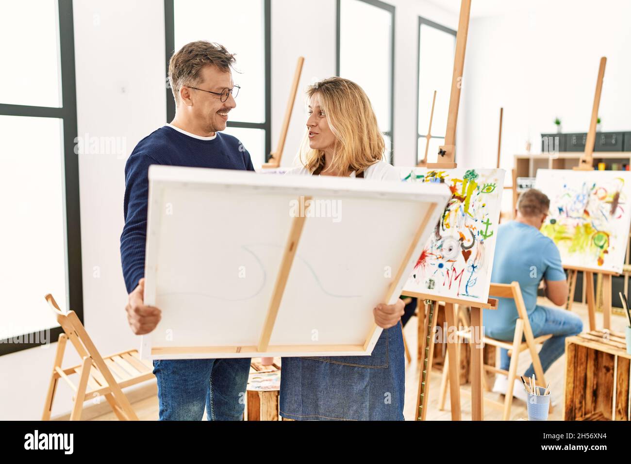 Group of middle age people drawing at art studio. Two students smiling ...