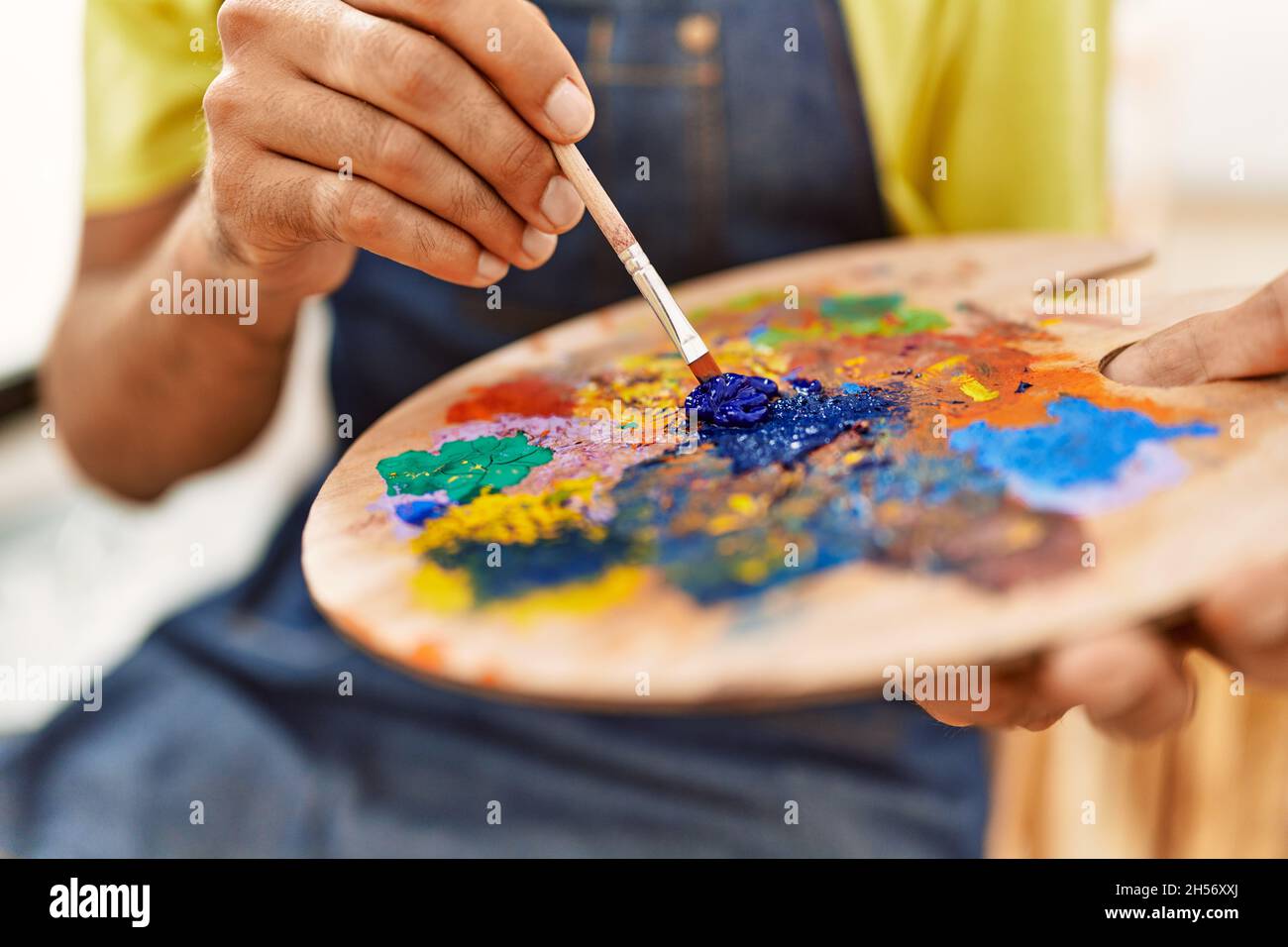 Artist man mixing colors on palette at art studio Stock Photo - Alamy