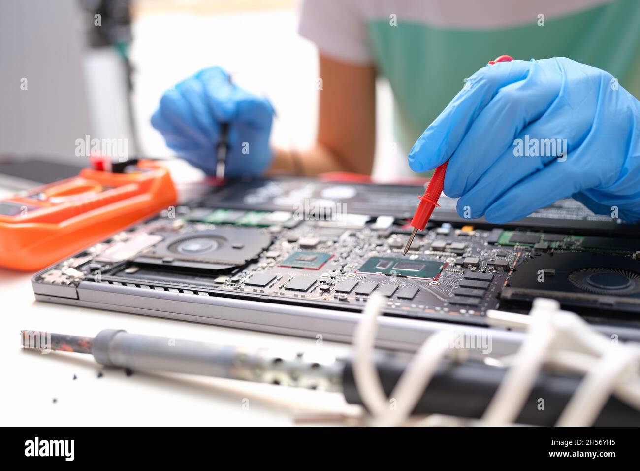 Laptop repair, hands hold voltage meter for electronics Stock Photo - Alamy