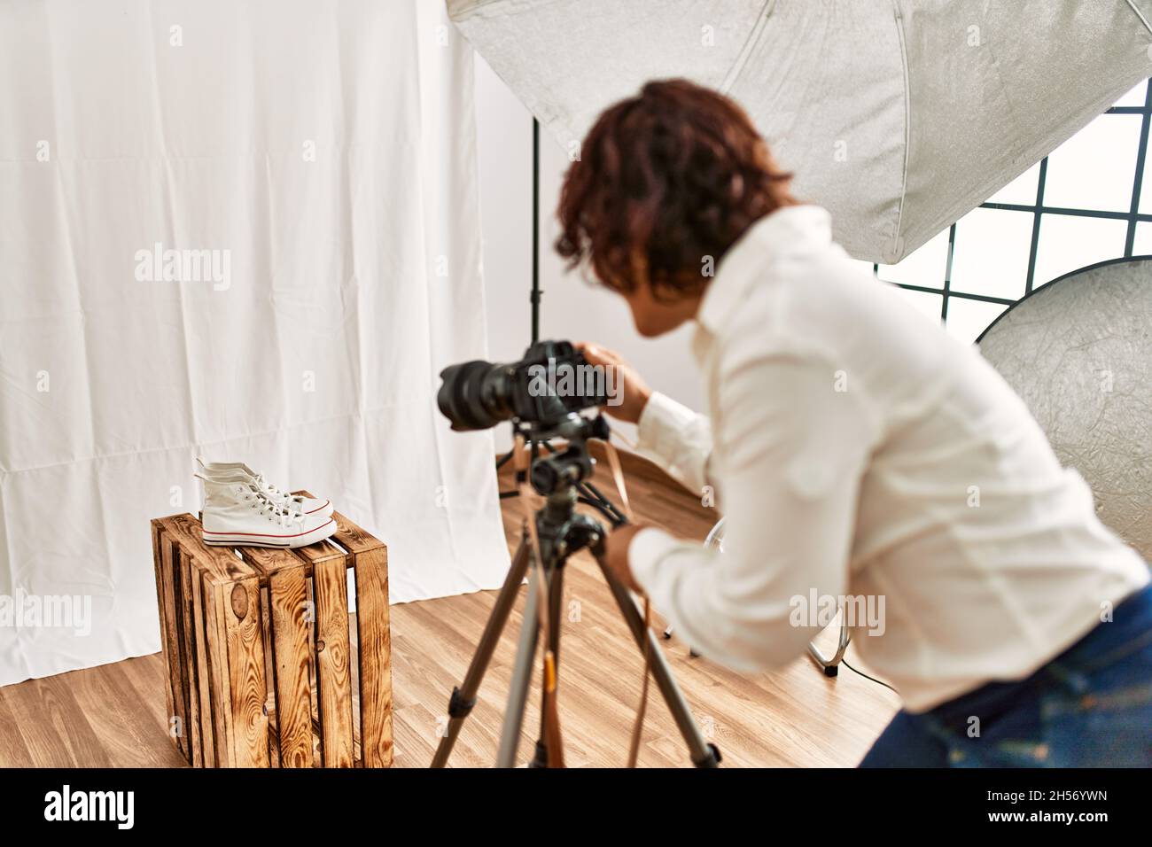 Young hispanic photographer woman on back view using camera at photo ...