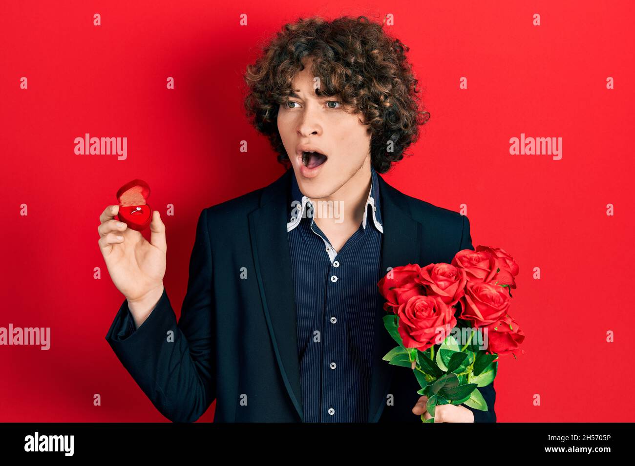 Handsome young man holding bouquet of flowers and engagement ring angry ...