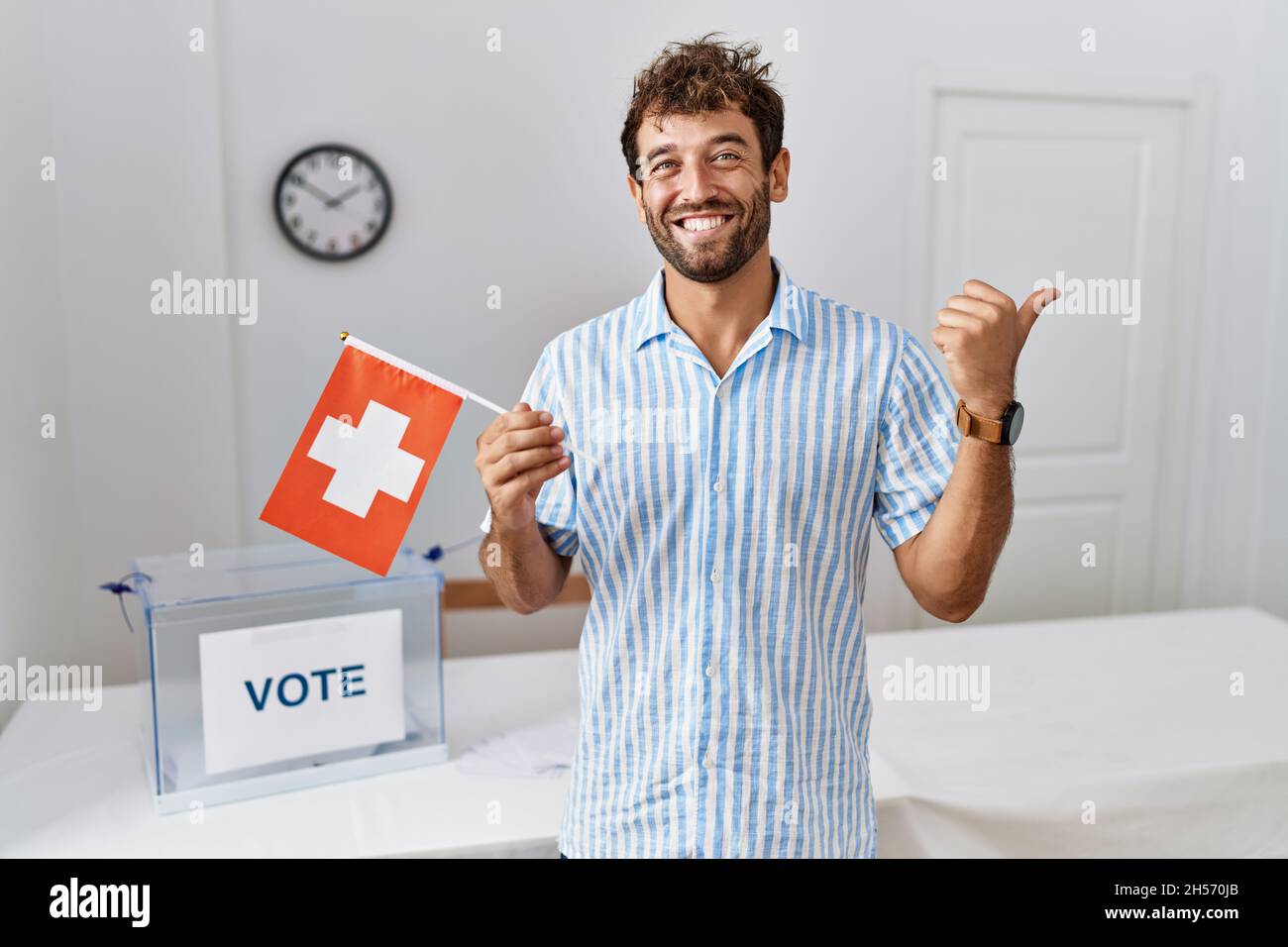 Young handsome man at political campaign election holding switzerland ...