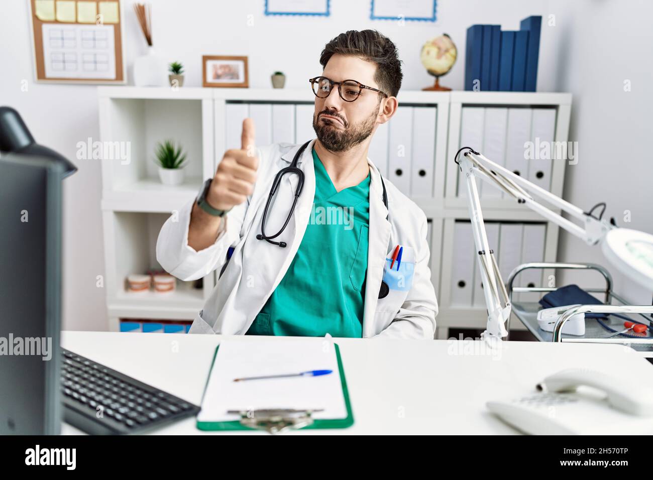 Young man with beard wearing doctor uniform and stethoscope at the ...