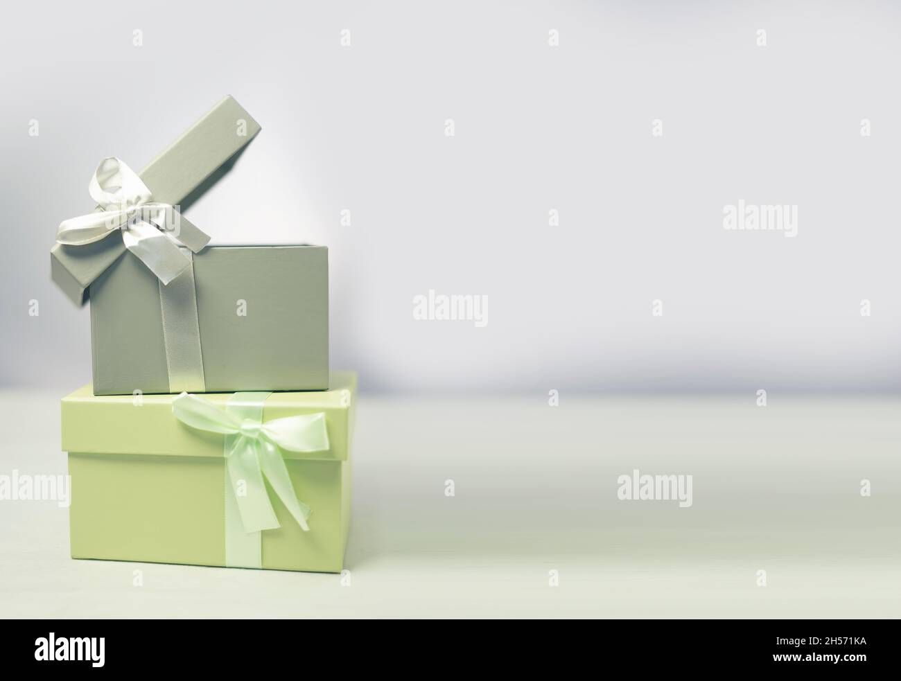 Pastel green and grey gift boxes standing over each other with white ...