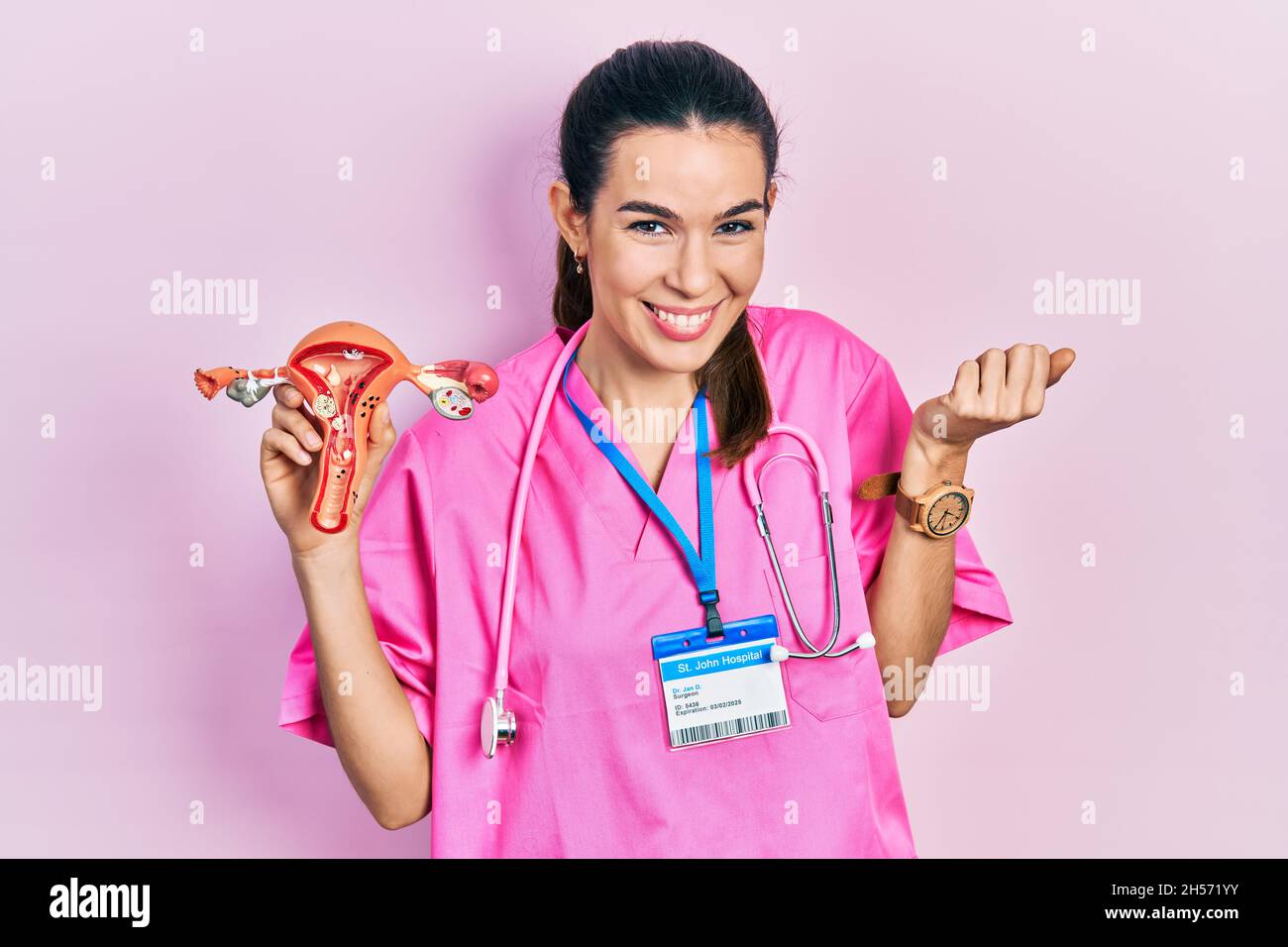 Young brunette doctor woman holding anatomical model of female genital ...