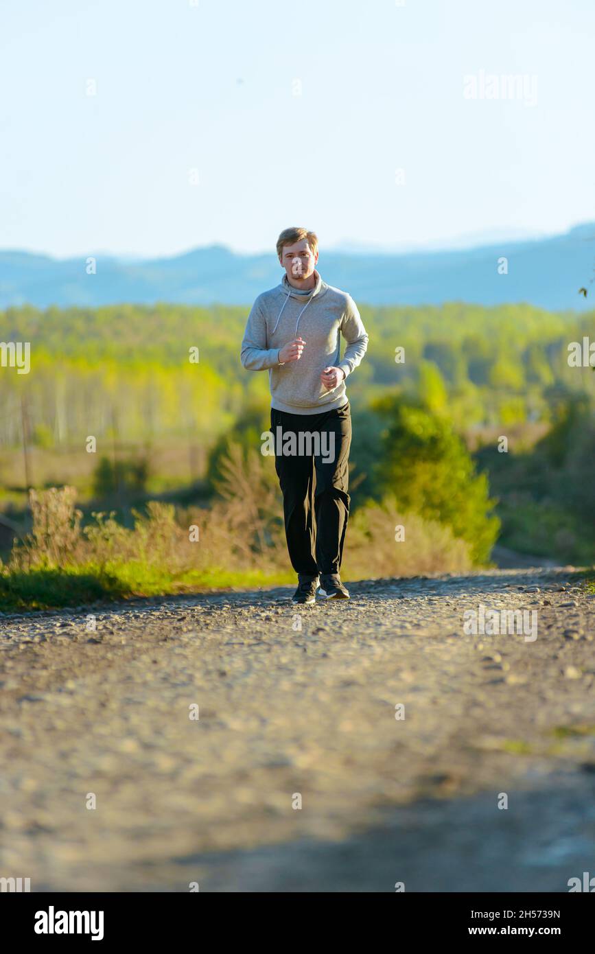 Running man jogging in rural nature at beautiful summer day. Sport ...