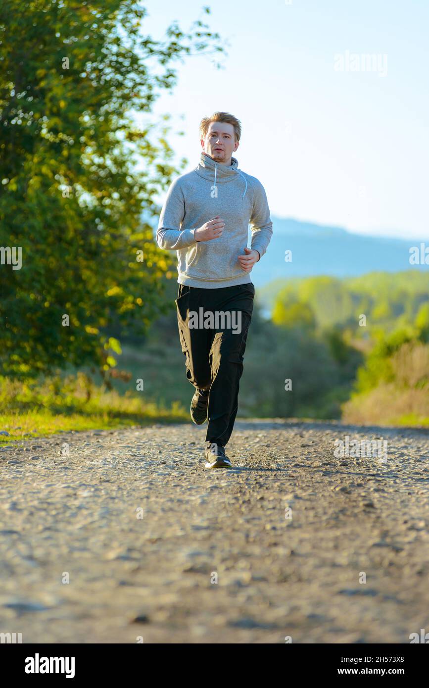 Running man jogging in rural nature at beautiful summer day. Sport ...