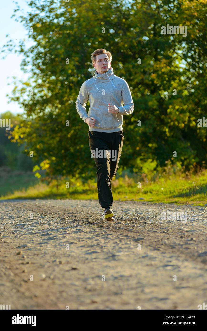 Running man jogging in rural nature at beautiful summer day. Sport ...