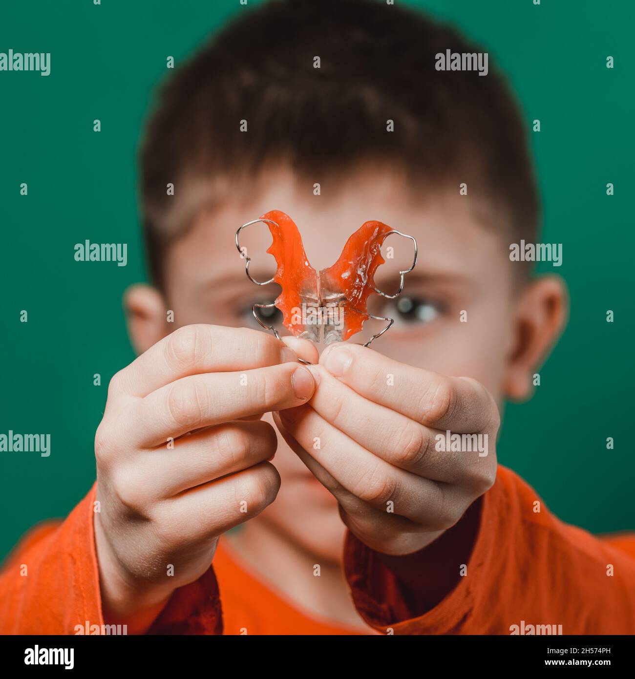 Dental plate to align deformed teeth, the boy holds his dental floss in ...