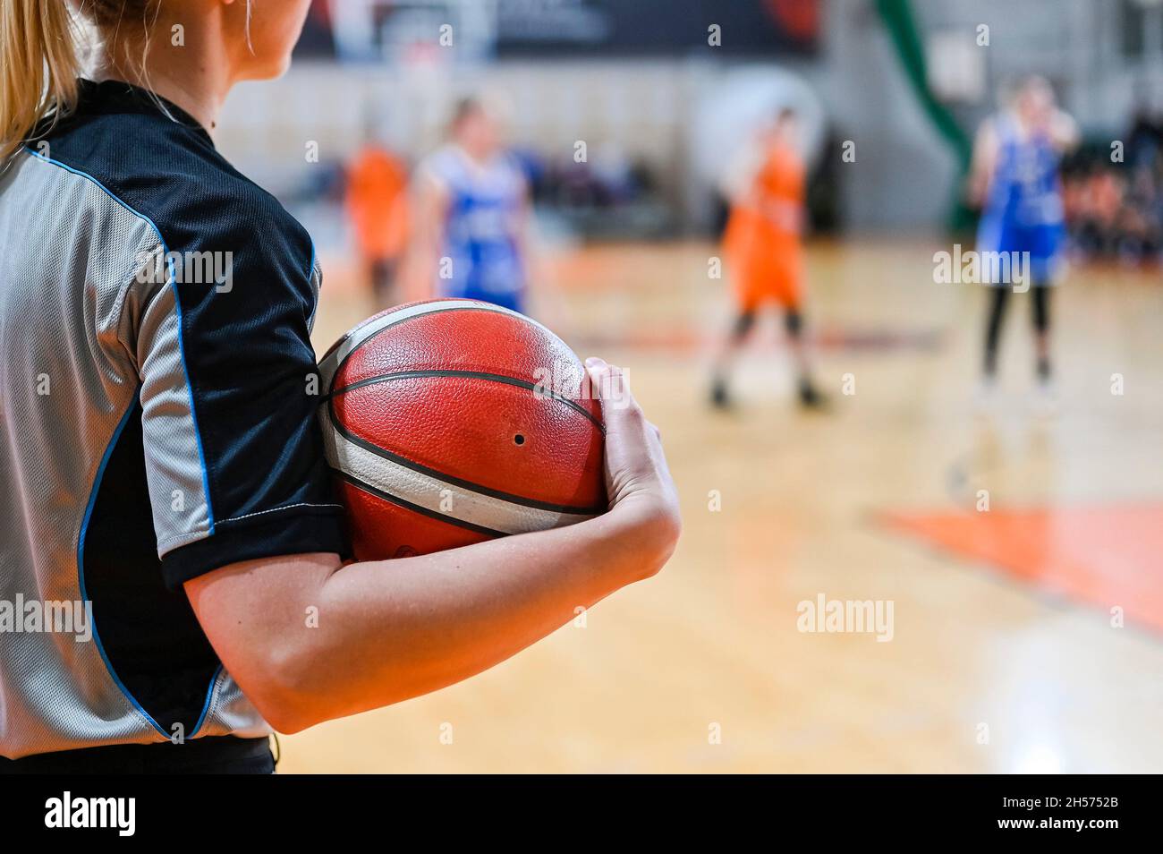 Woman referee keeps the ball during basketball match Stock Photo - Alamy