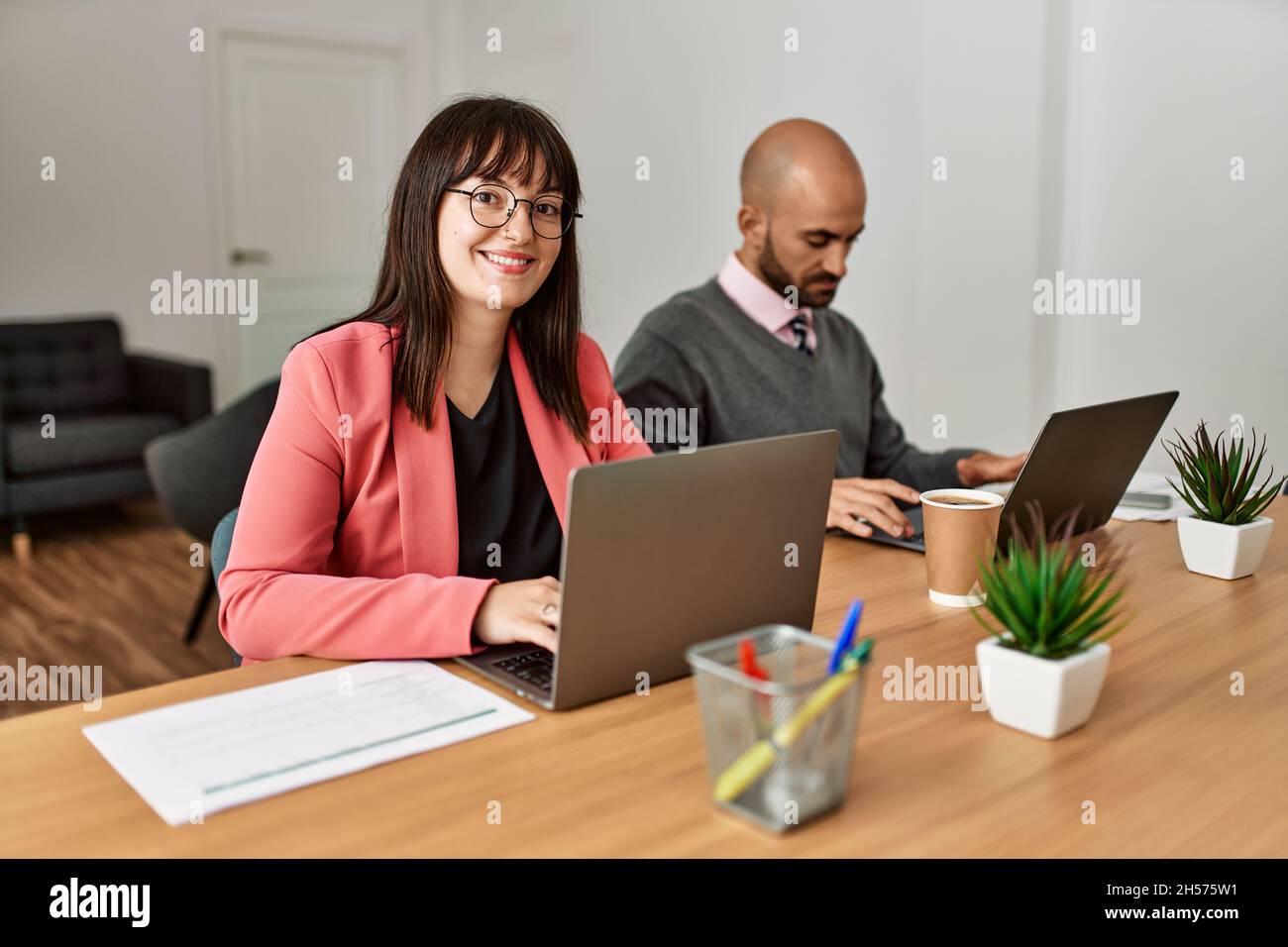 Two hispanic business workers smiling happy working at the office Stock ...
