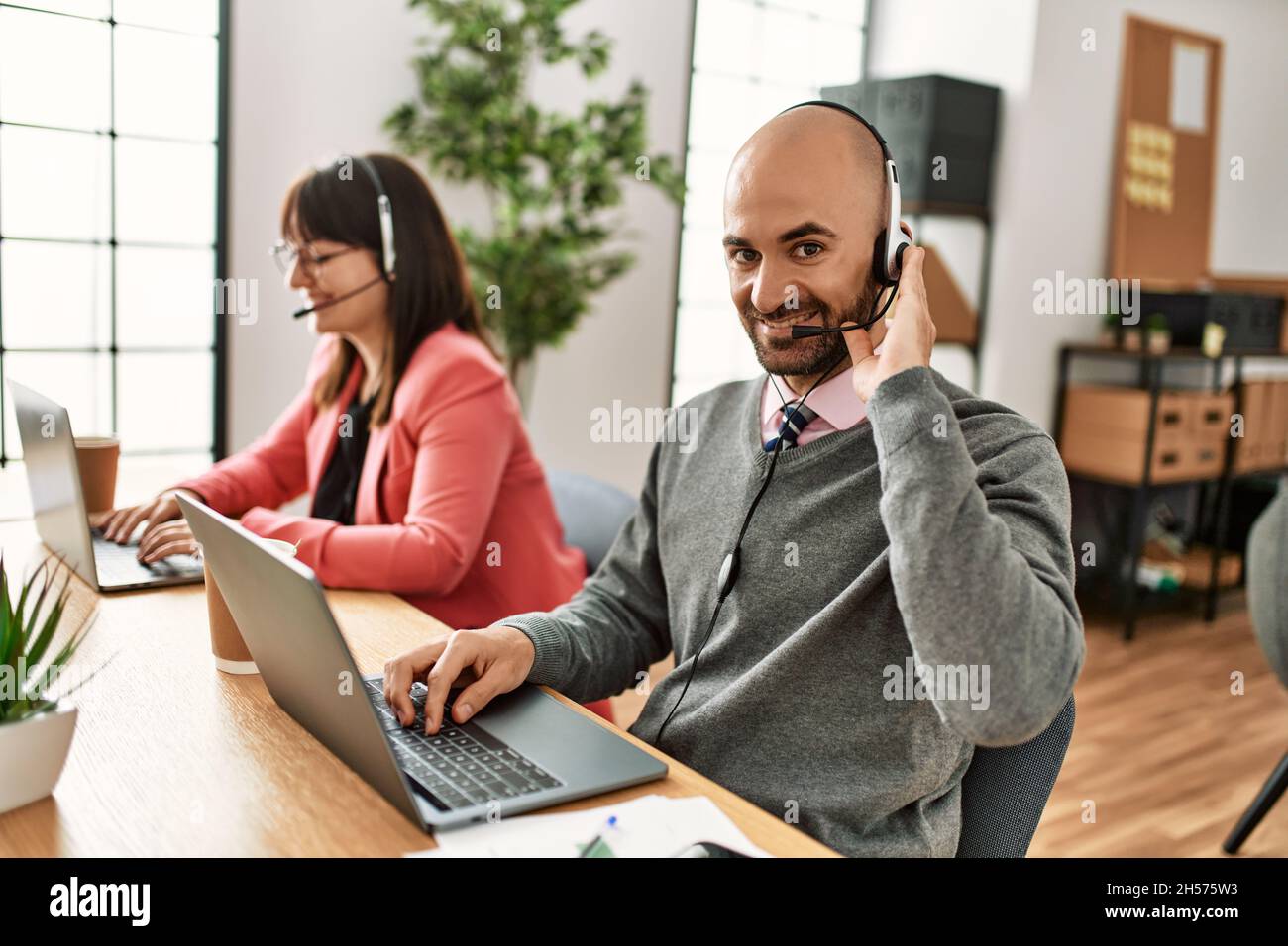 Two call center agent smiling happy working at the office Stock Photo ...