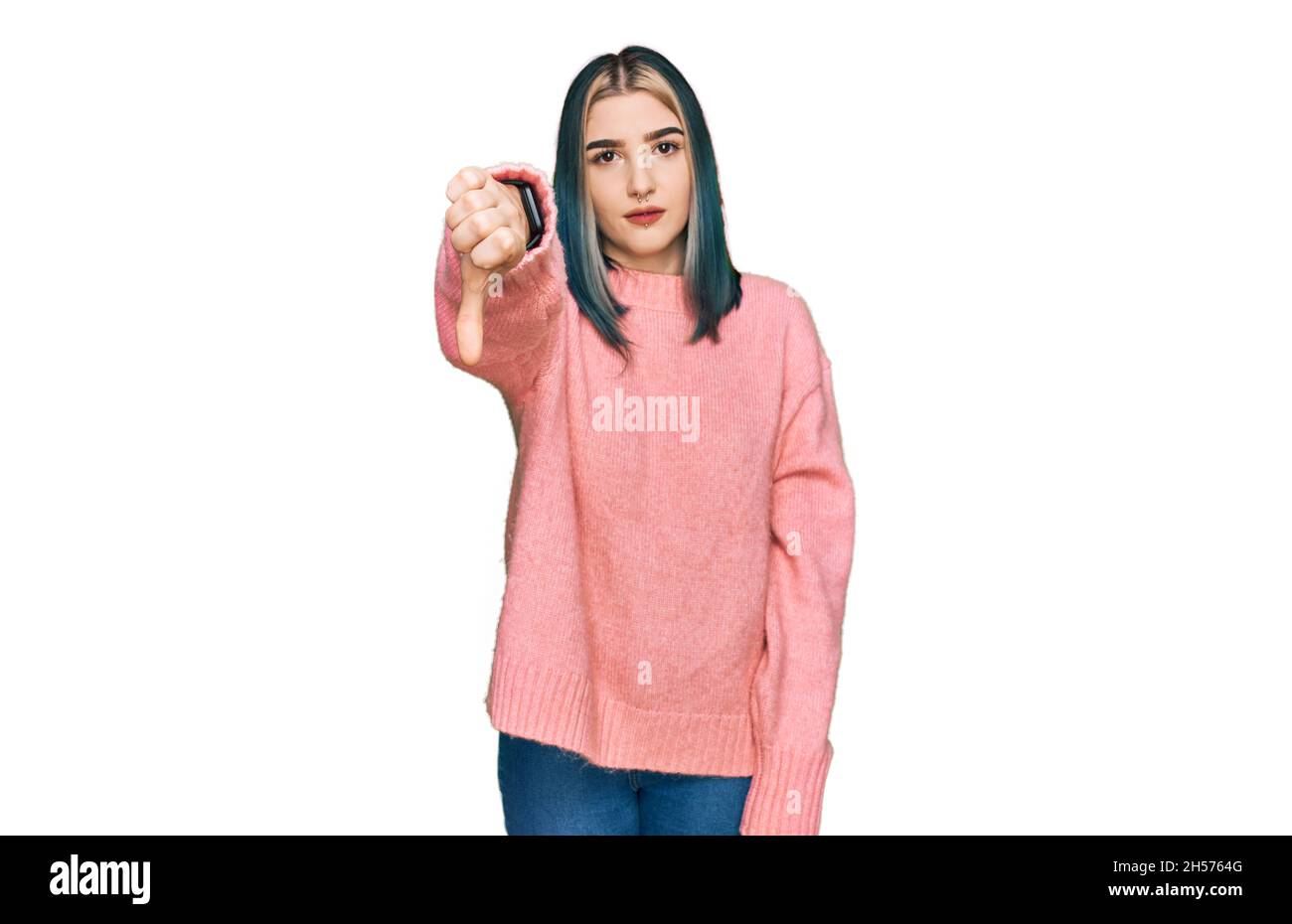 Young modern girl wearing pink wool winter sweater looking unhappy and ...