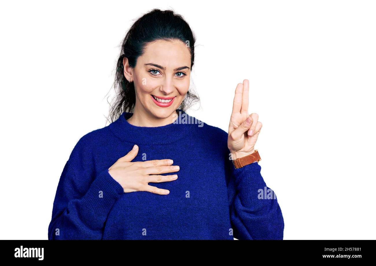 Young hispanic woman wearing casual clothes smiling swearing with hand ...