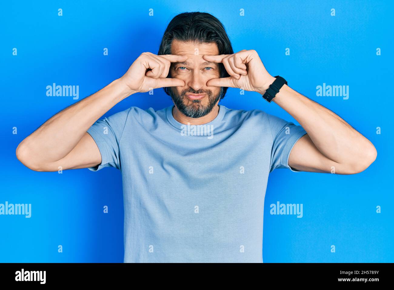 Middle age caucasian man wearing casual clothes trying to open eyes ...