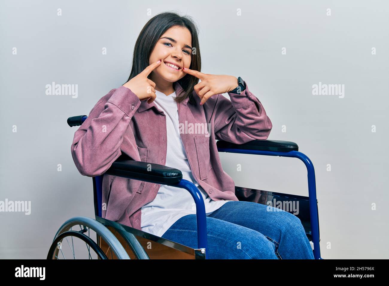 Young brunette woman sitting on wheelchair smiling with open mouth ...